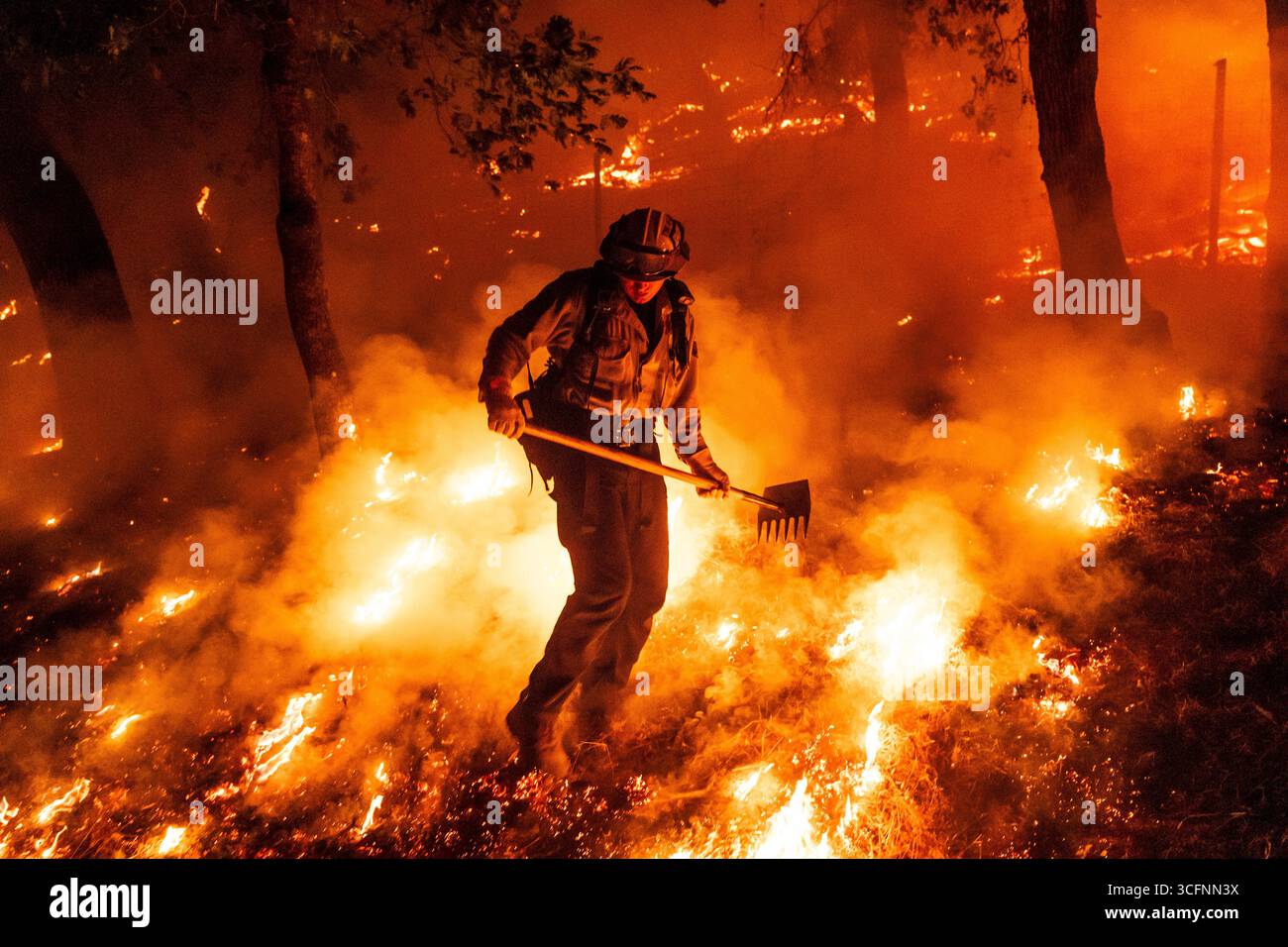 A firefighter battles the Pickett Fire burning in the Aetna Springs ...