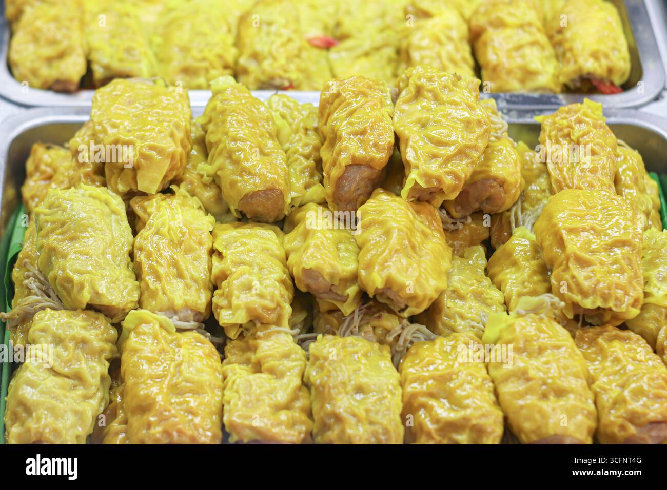 Thai steamed dumplings or shumai with pork and enoki mushrooms, golden ...
