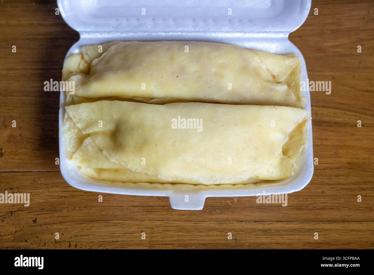 Traditional Bengali sweet dish, Patishapta pitha, in a disposable foam ...
