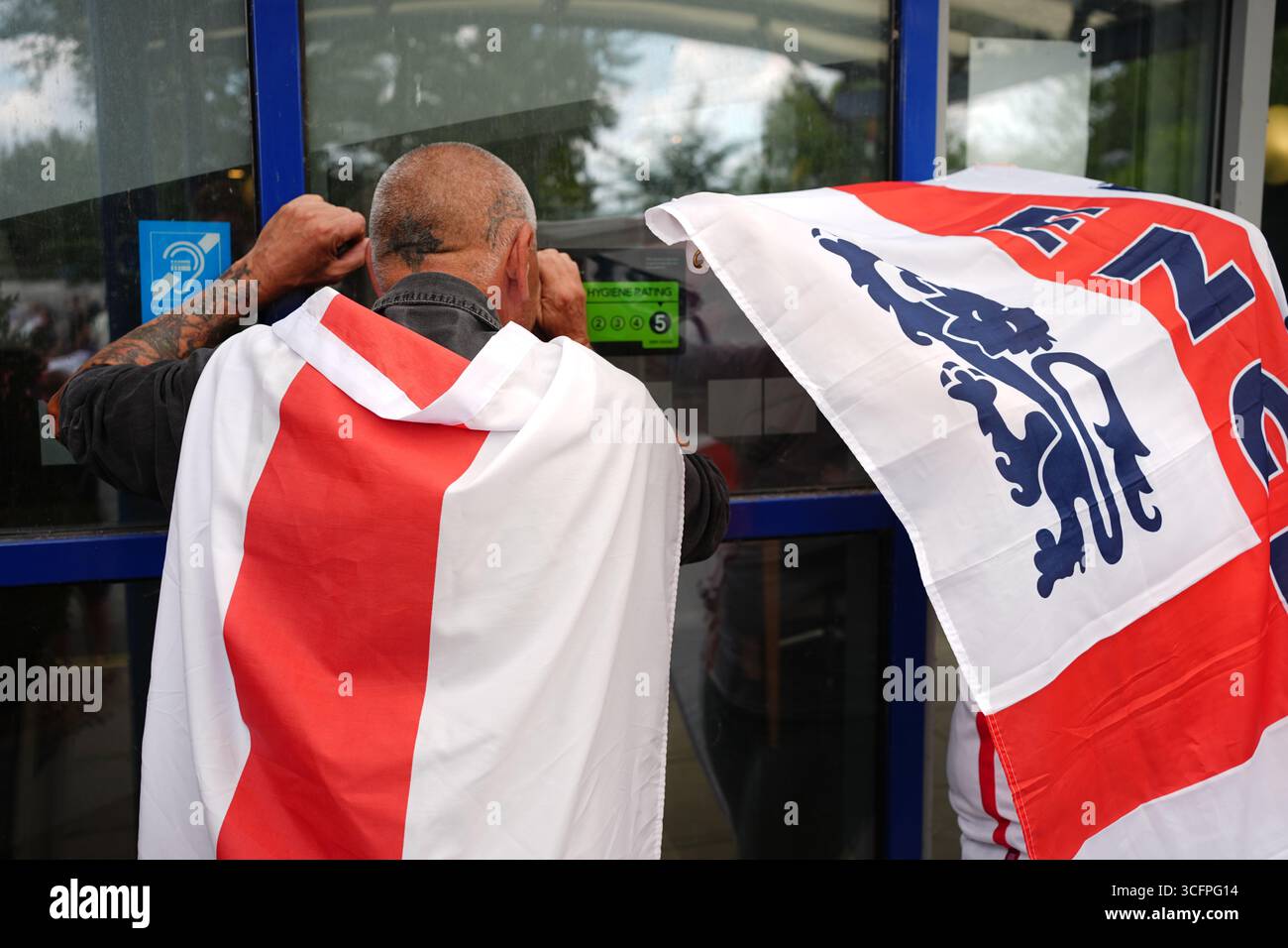 Protesters look through a door as people demonstrate under the Abolish ...