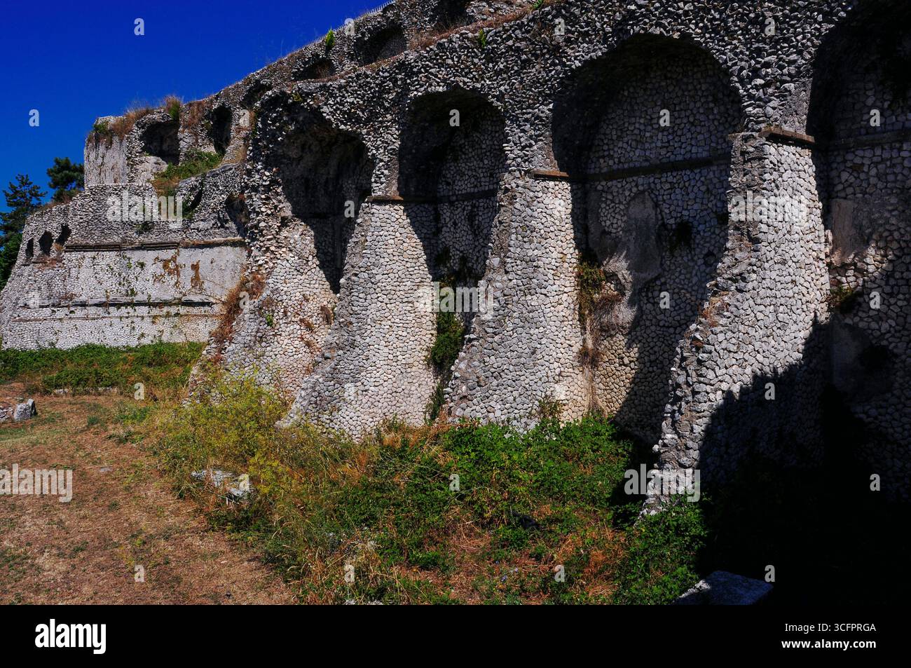 Roman stone arches and piers support hillside terrace below circular ...