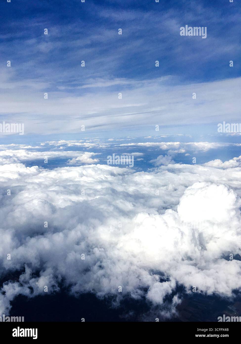 A vertical photo of view of the sky above clouds with a blue sky white ...