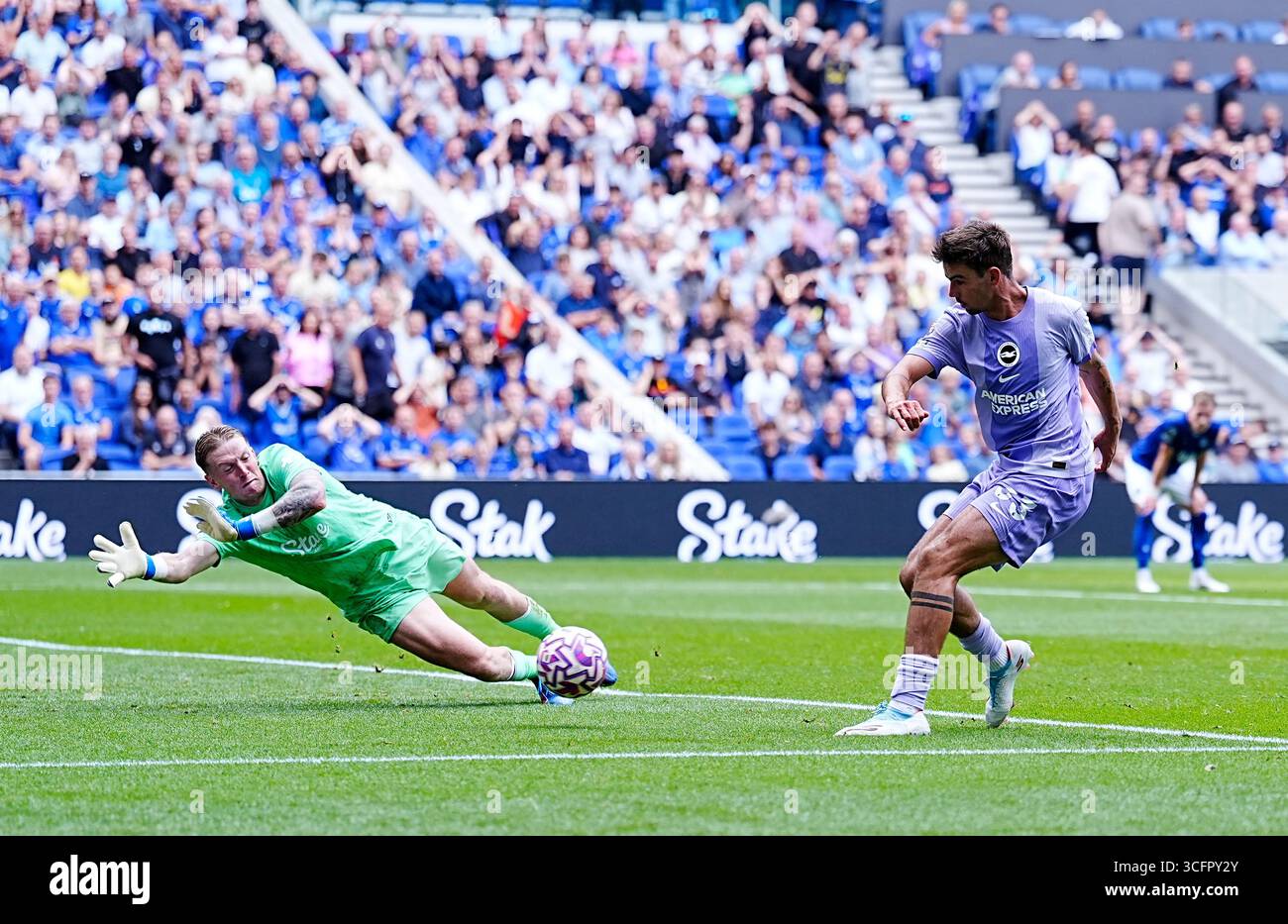 Brighton and Hove Albion's Matt O'Riley (right) has a shot saved by ...