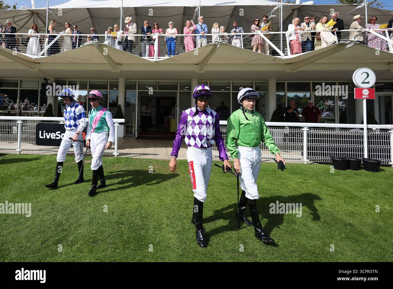 Jockeys wait to enter the pre-parade ring, before the fourth race at ...