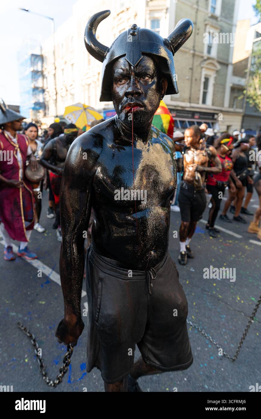 London, UK. 24 August 2025. Participants clad in black paint, horns ...
