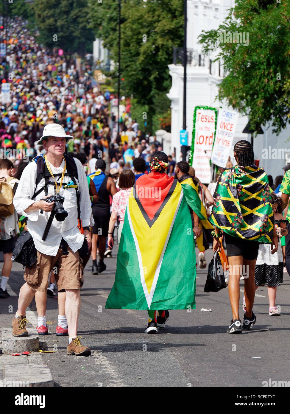 People with flags draped over shoulders beside a photographer with ...