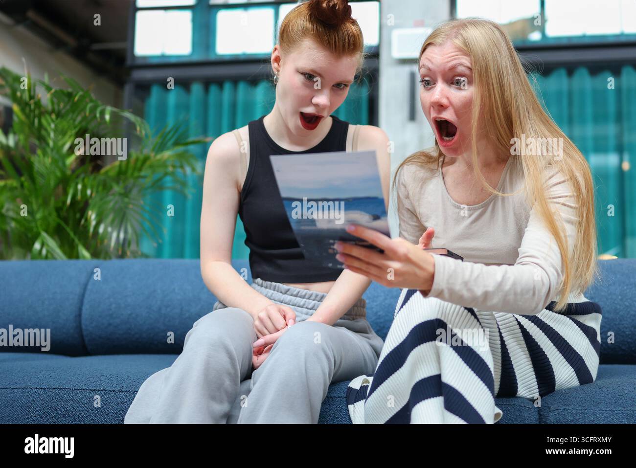 Shocked and amazed female friends reading unexpected news together on a ...