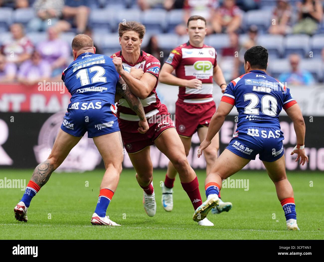 Wigan Warriors' Sam Walters is tackled by Wakefield Trinity's Josh ...
