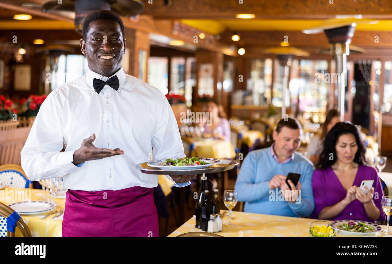 Positive African-american waiter with tray in restaurant Stock Photo ...