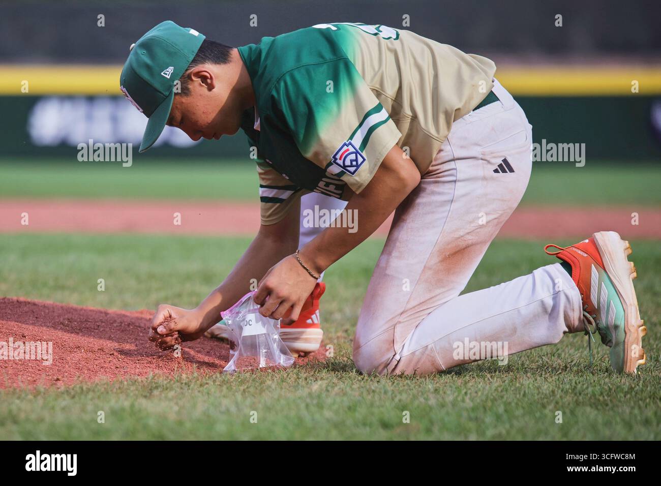 Taiwan's Lin Chin-Tse collects dirt from the pitcher's mound after ...