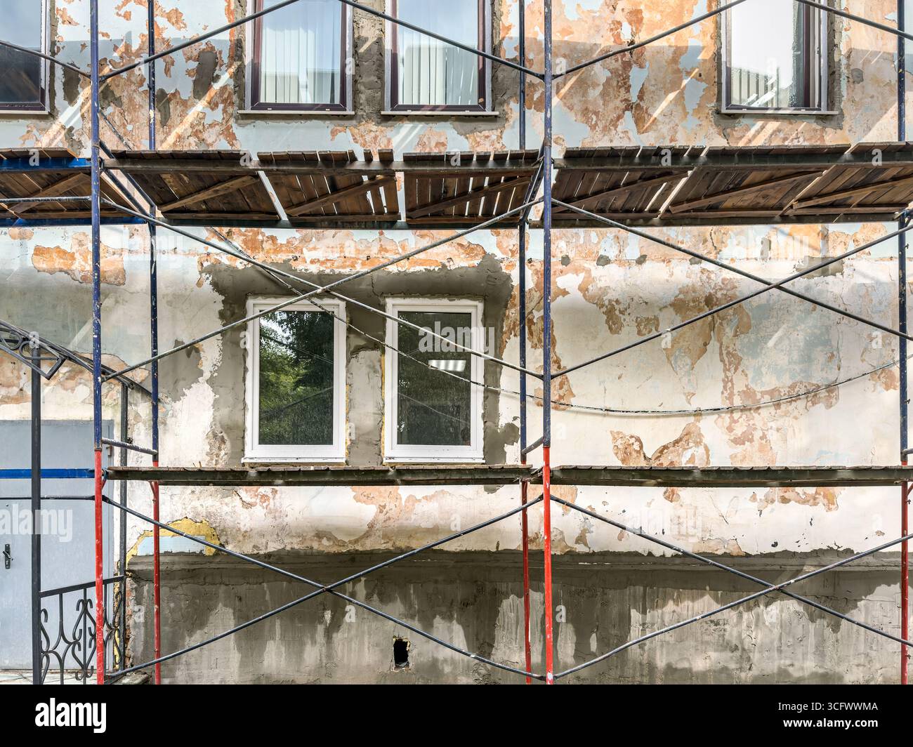 facade of an old building under renovation with construction scaffolds ...