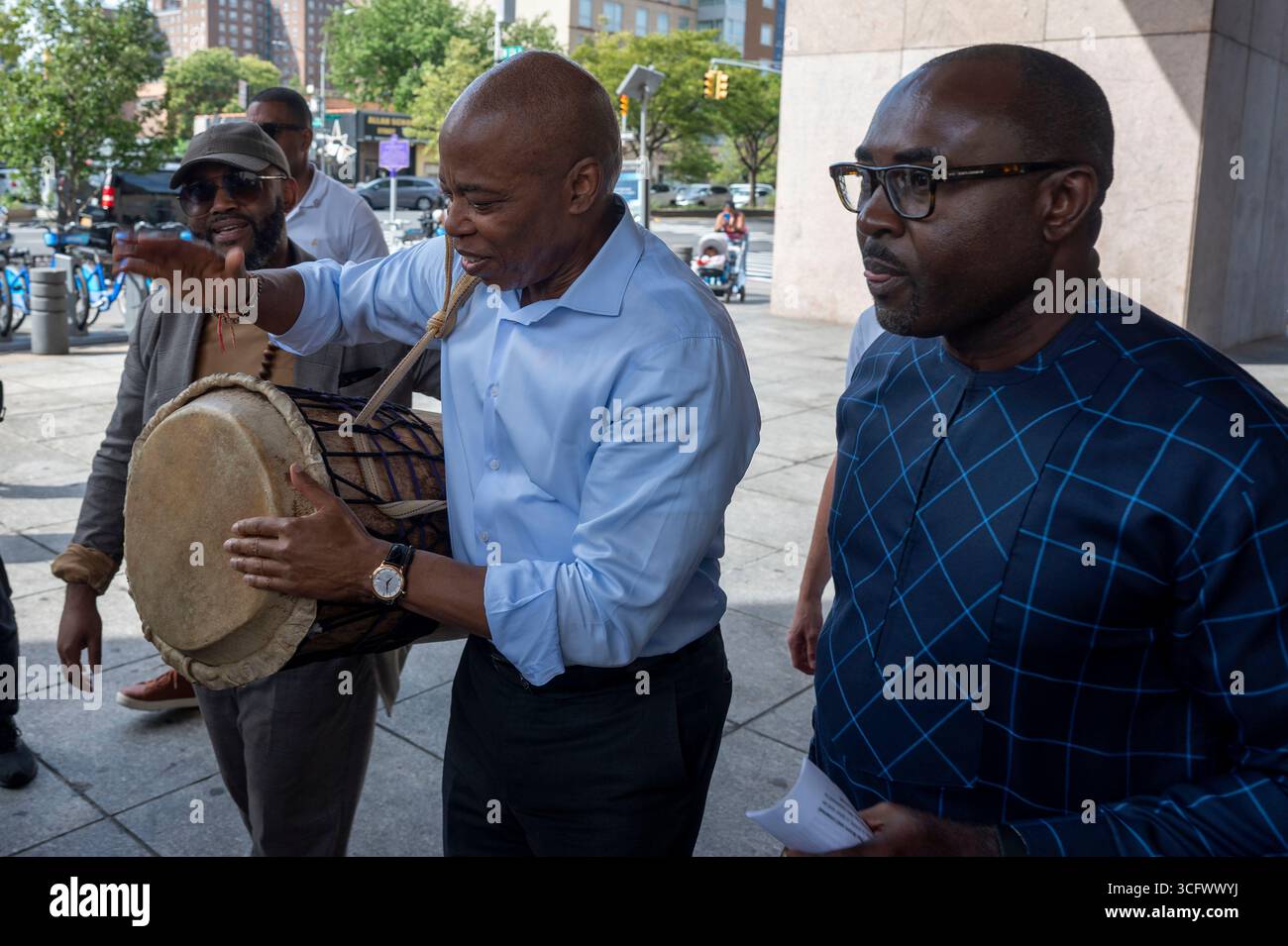 New York City Mayor Eric Adams (C) plays a drum at a campaign event ...
