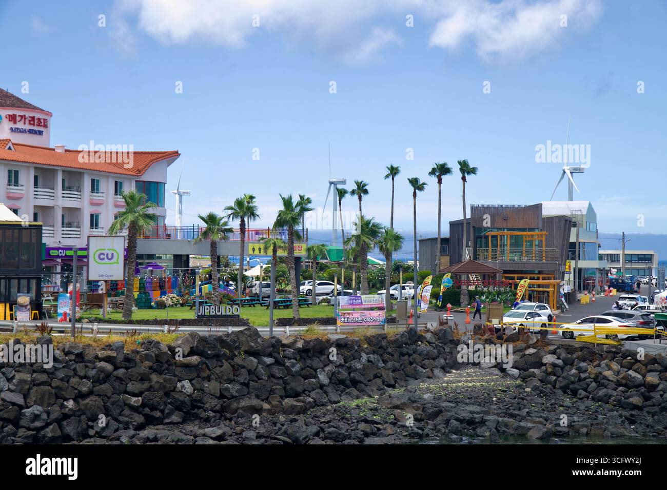 Shops, cafés, and a convenience store front the waterfront lawns at ...