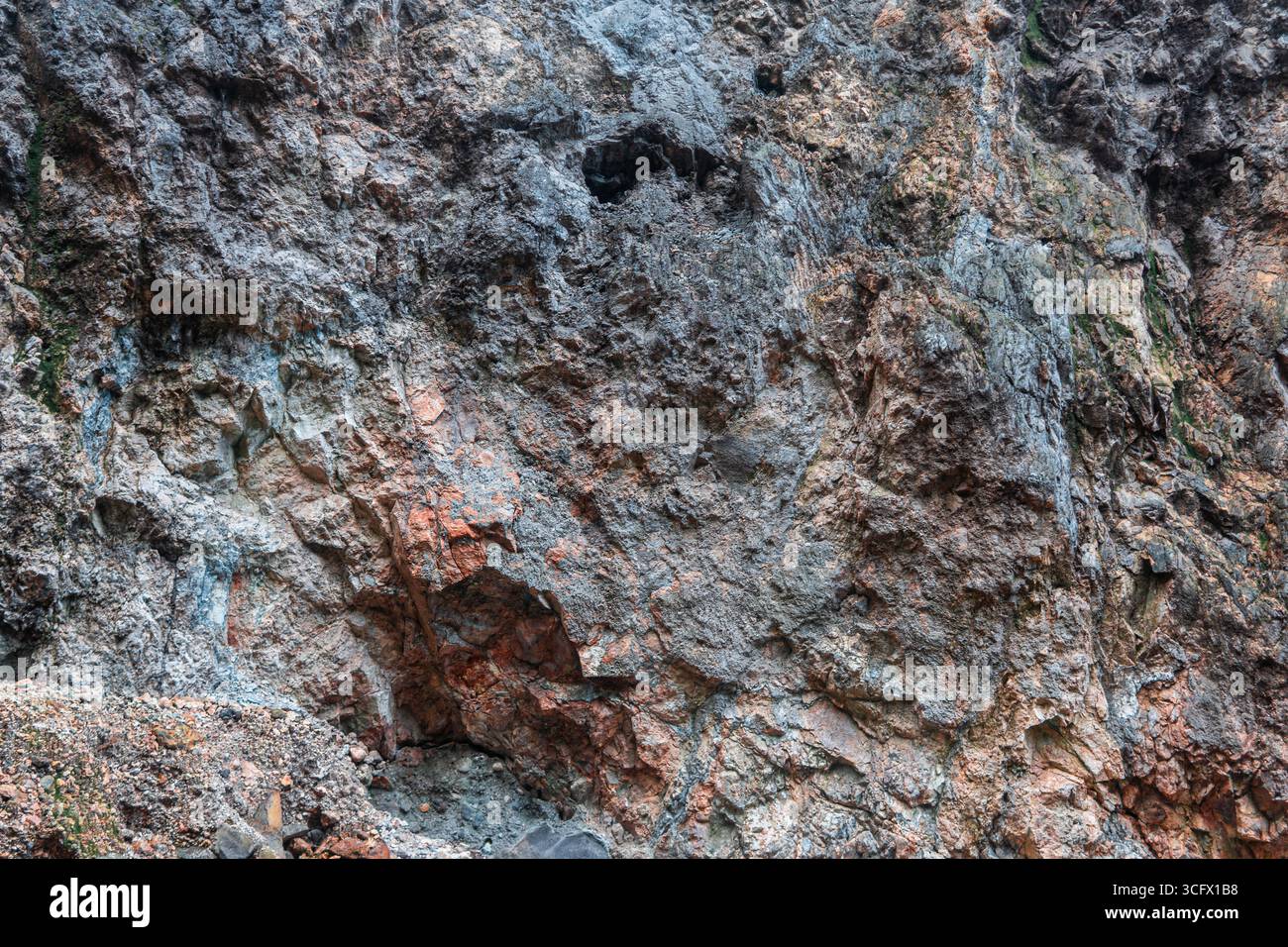 Detailed texture of a natural rock cliff showing layers of stone with ...