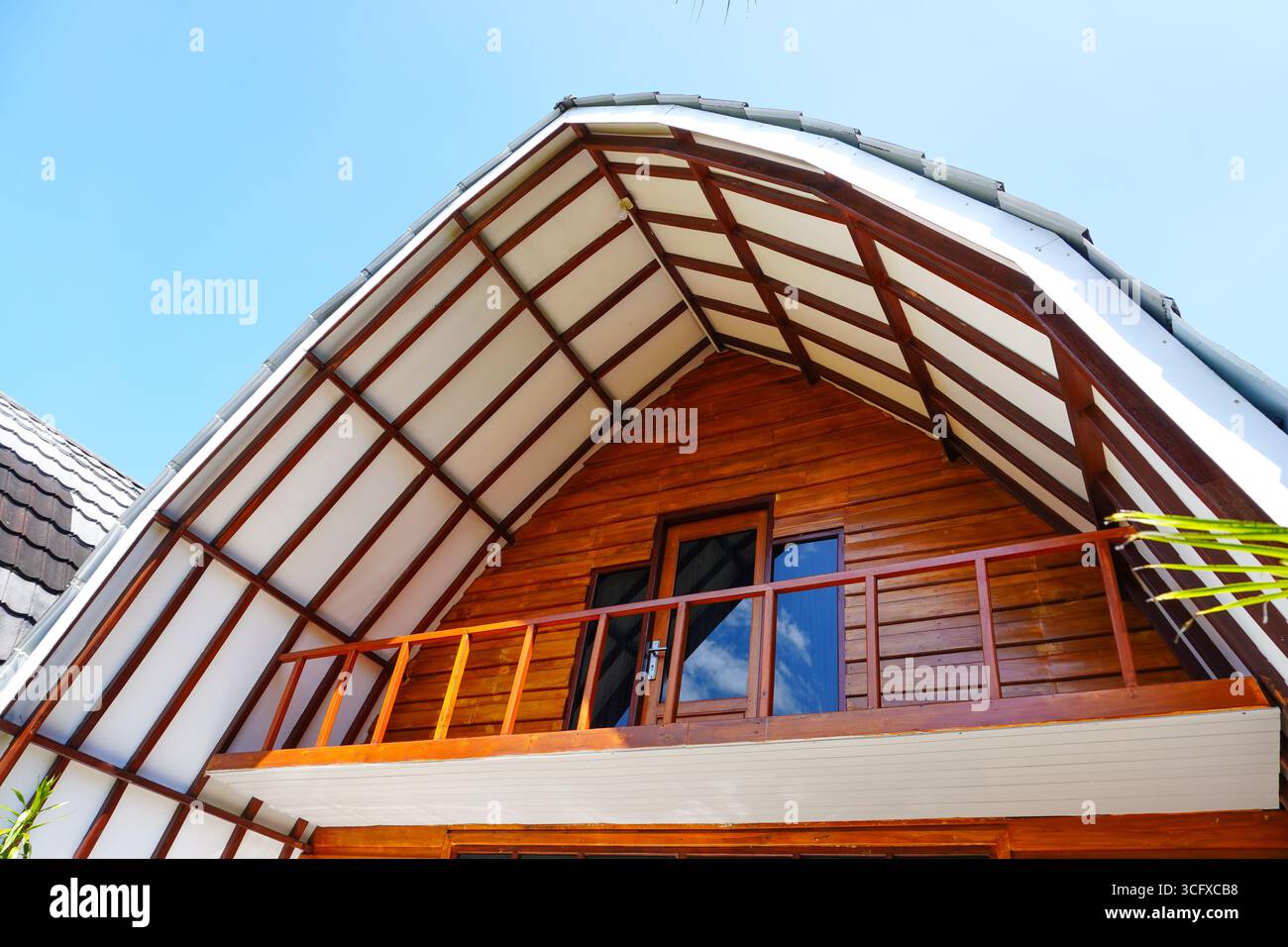 Wooden chalet exhibits a distinctive gable roof and balcony, its dark ...