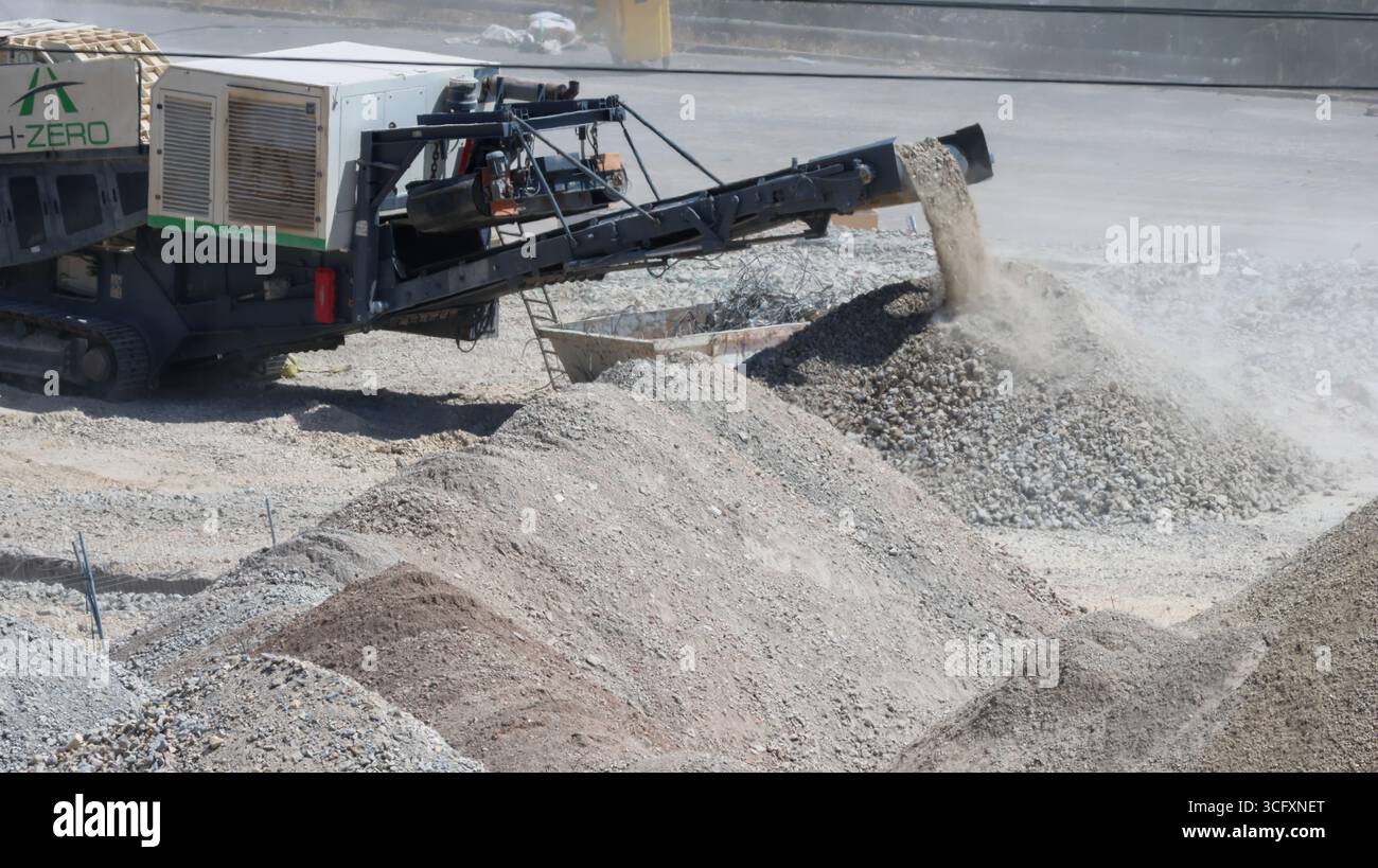 Conveyor belt depositing crushed concrete and debris into piles ...
