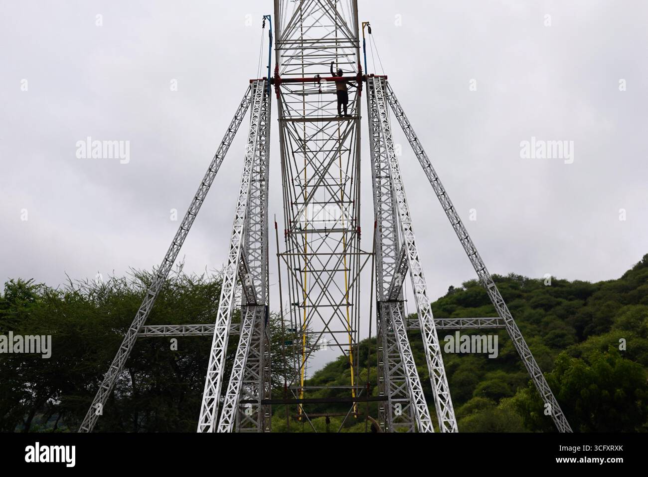 A Labourer works on a giant ferris wheel, ahead of the Hindu folk deity ...