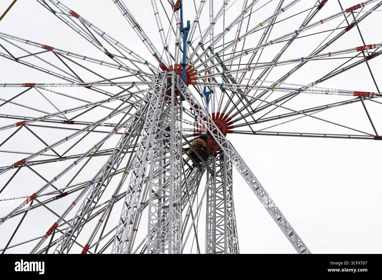 A Labourer works on a giant ferris wheel, ahead of the Hindu folk deity ...