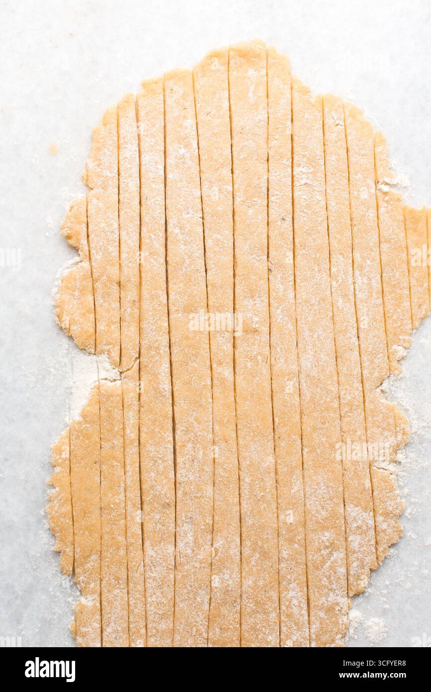 Nigerian Chin chin dough being cut on a white granite countertop, Raw ...
