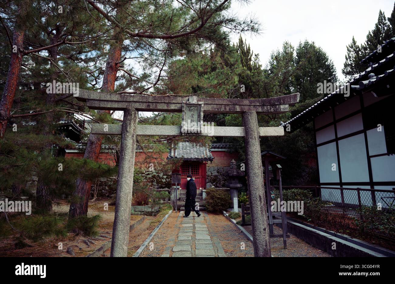 Stone torii gate framing the entrance to a small shrine in Kyoto, with ...