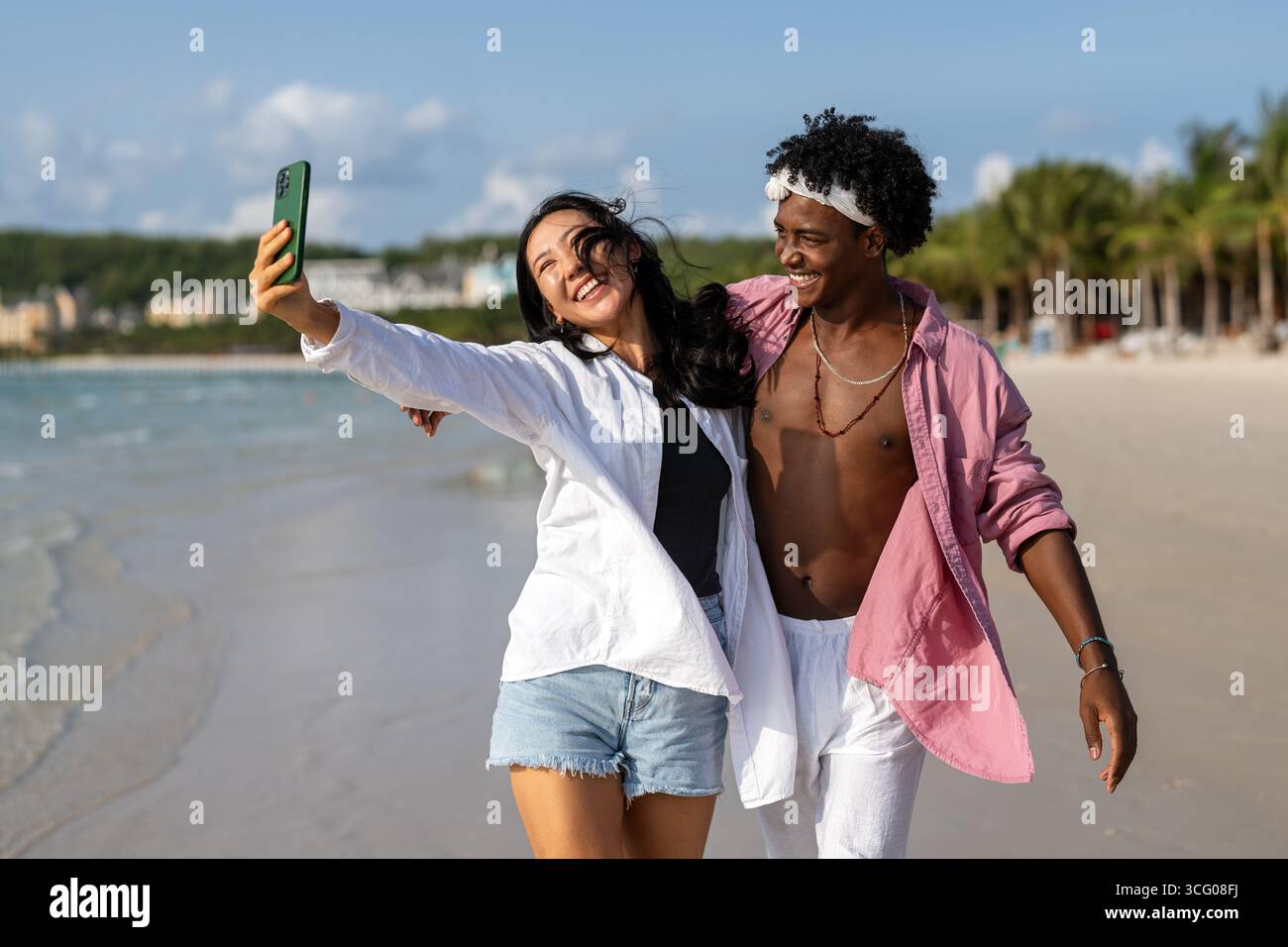 Trendy digital creator couple taking a stylish selfie by the beach ...