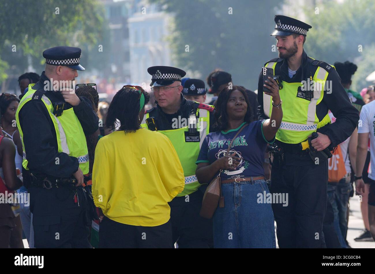 A women takes a selfie on her mobile phone with police officers at the ...