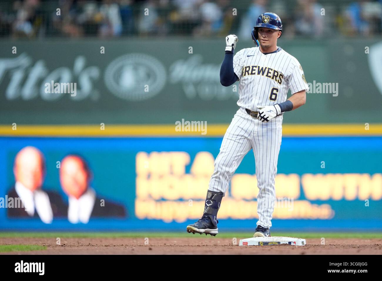 Milwaukee Brewers' Isaac Collins gestures to the dugout after hitting a ...