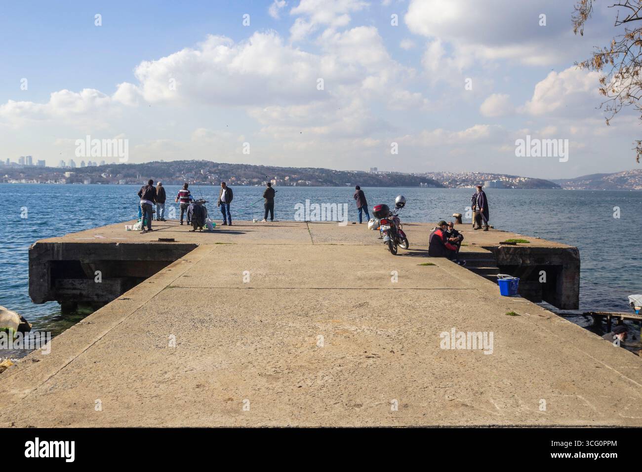 istanbul landscape with men fishing from a jetty overlooking the city ...
