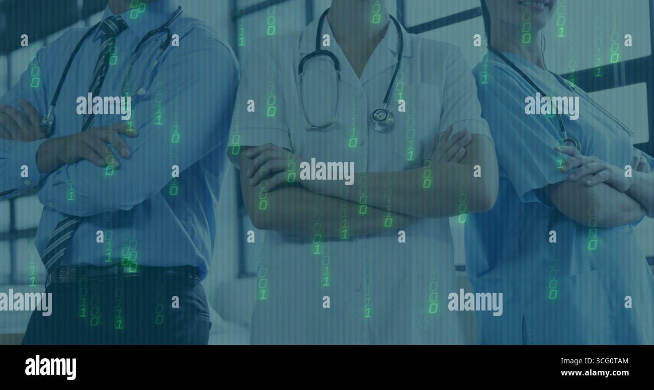 Standing healthcare trio crossing arms in windowed corridor, with ...