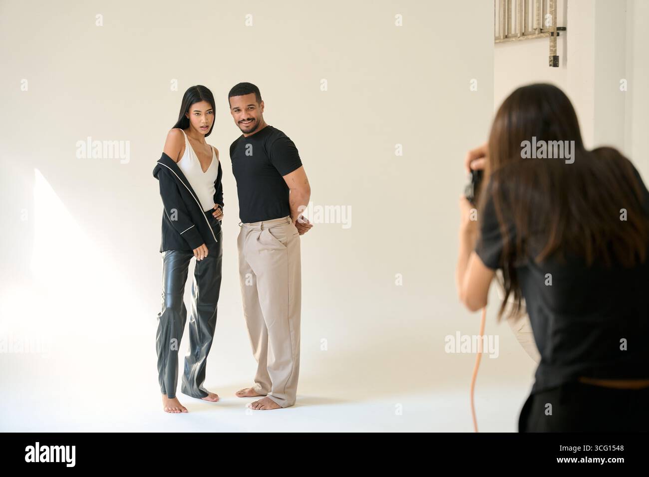 Photographer taking pictures of fashion models in studio Stock Photo ...