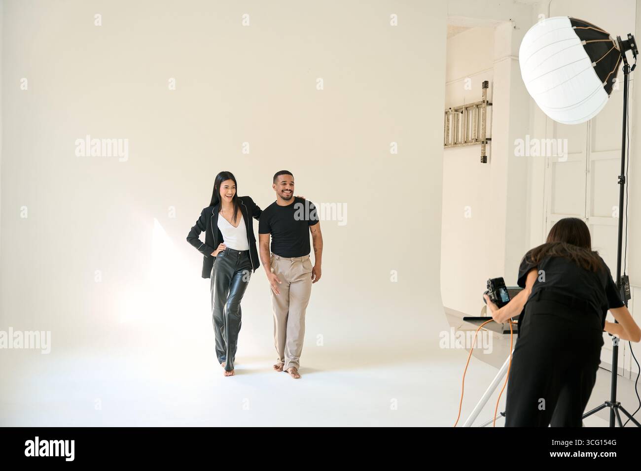 Photographer taking photos of models posing in studio Stock Photo - Alamy