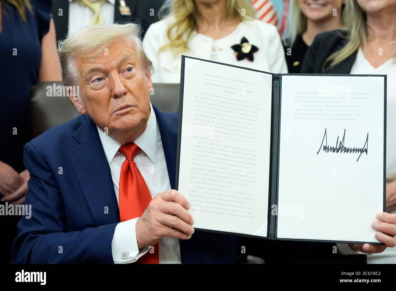 President Donald Trump holds up a signed proclamation in the Oval ...