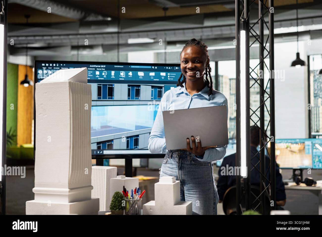 Real estate developer reviews master plan with construction layouts on laptop, ensuring the ...