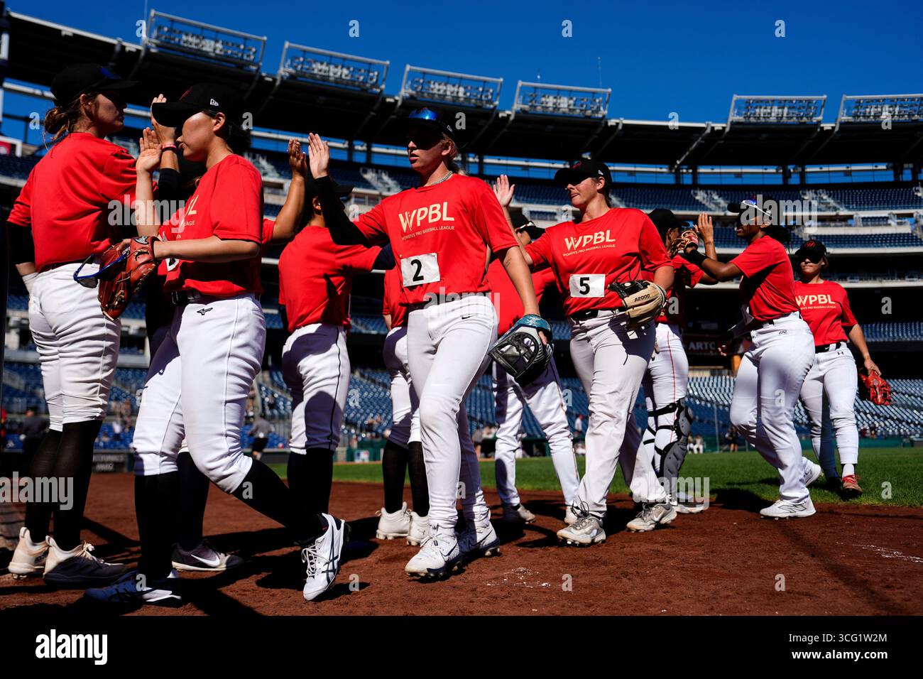 Players high-five while returning to the dugout during a game on the ...