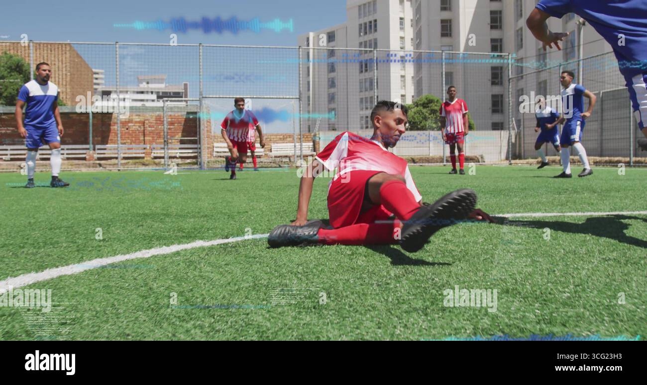 Sliding soccer player in red performing tackle on turf pitch, with ...
