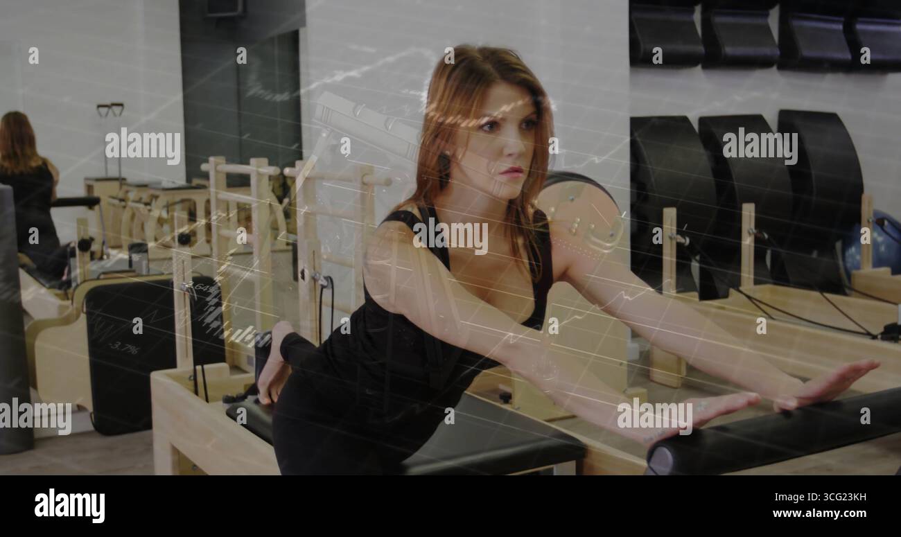 Performing Pilates exercise woman wearing black sportswear in Pilates ...