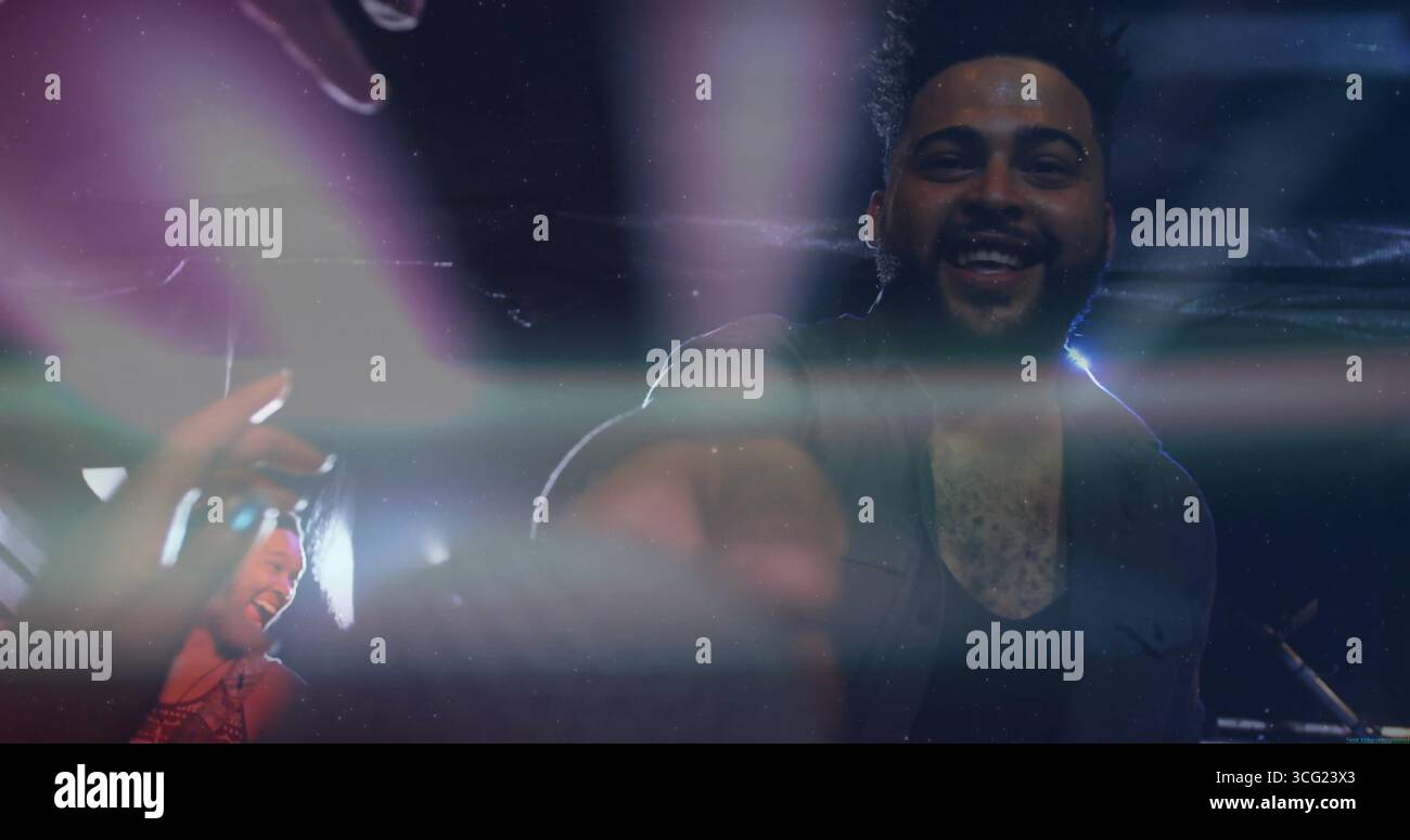 Smiling performer reaching toward camera at club stage, with mic stand ...
