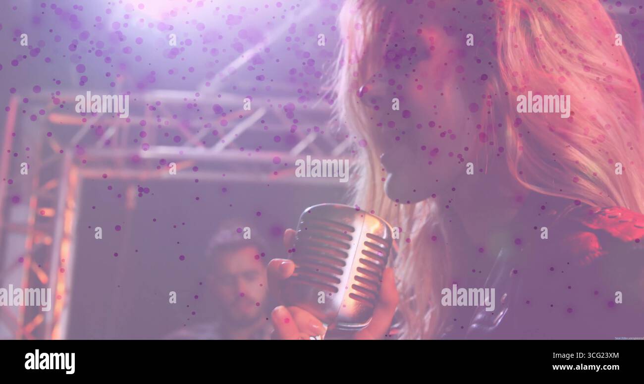 Singing female vocalist holding vintage microphone on dim stage, with ...