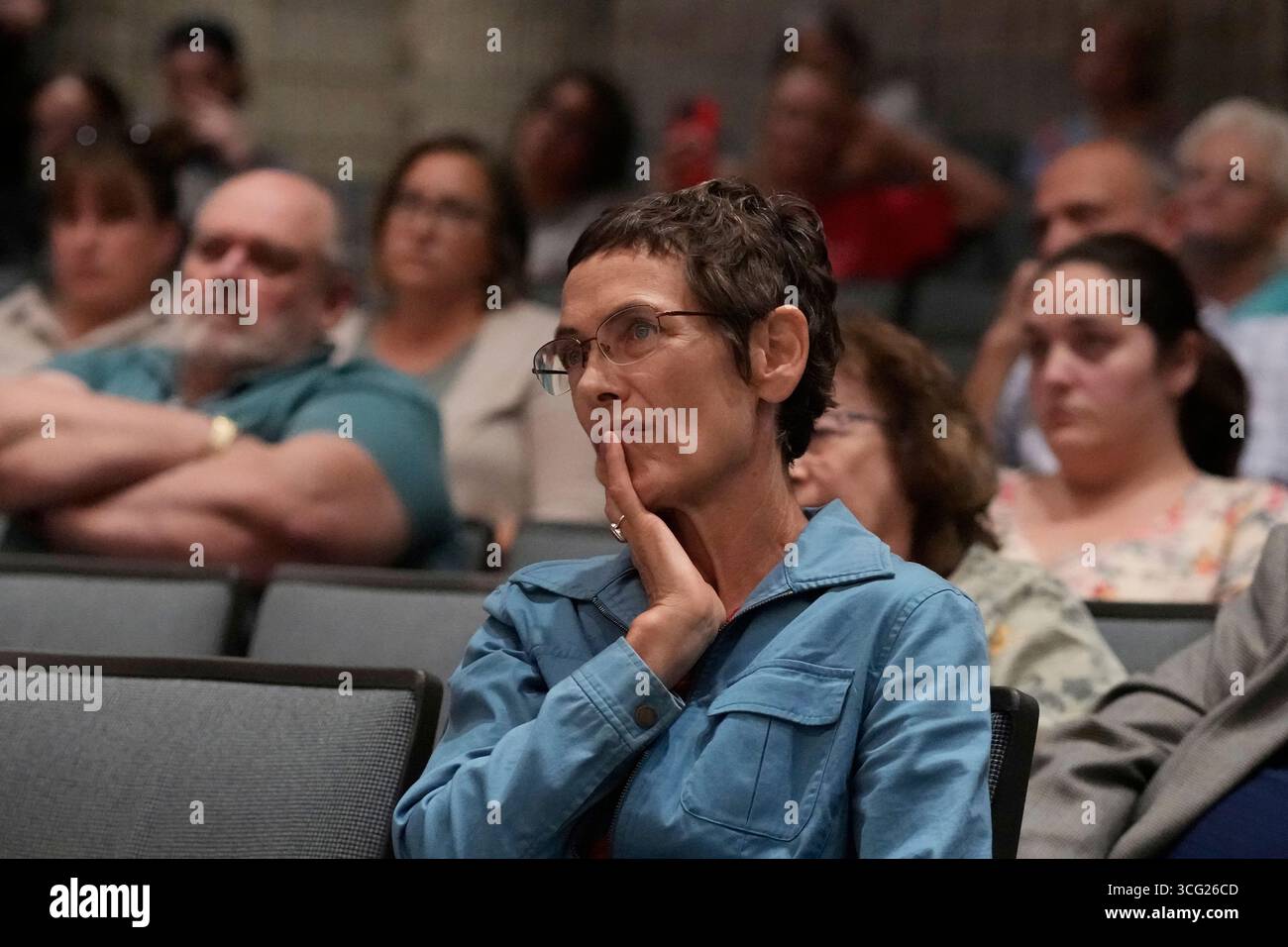 People listen as Republican Rep. Mark Alford addresses attendees at a ...