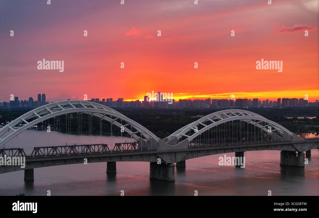 Sunset illuminates the sky over the Songhua River in Harbin City ...