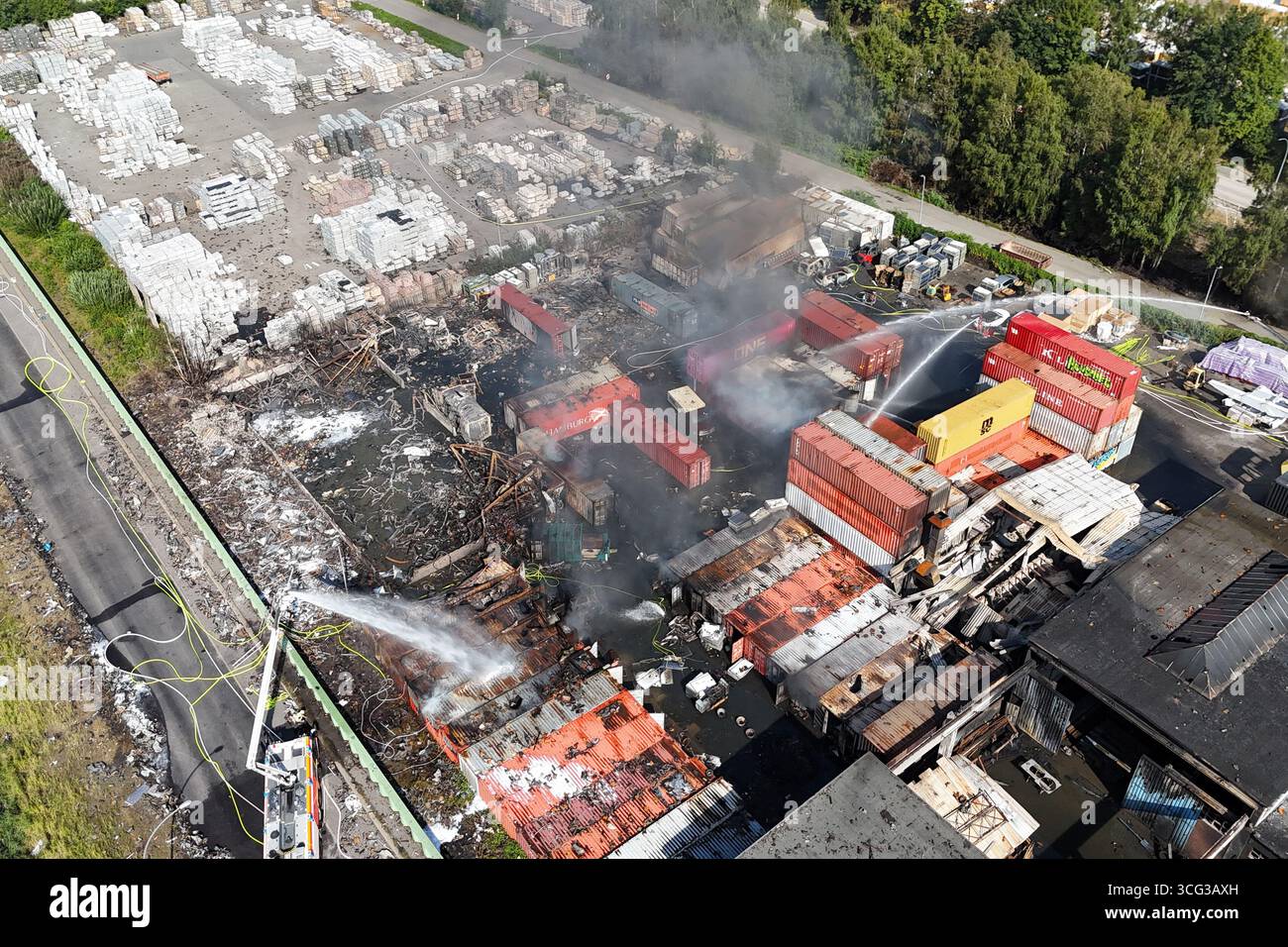 26 August 2025, Hamburg: Firefighters extinguish a fire in an ...