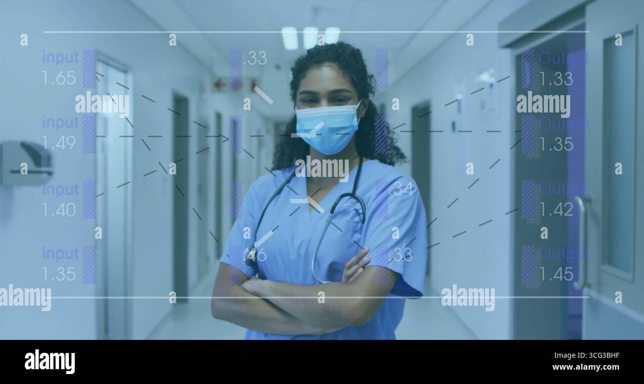 Standing nurse monitoring input output charts in lit hospital corridor ...
