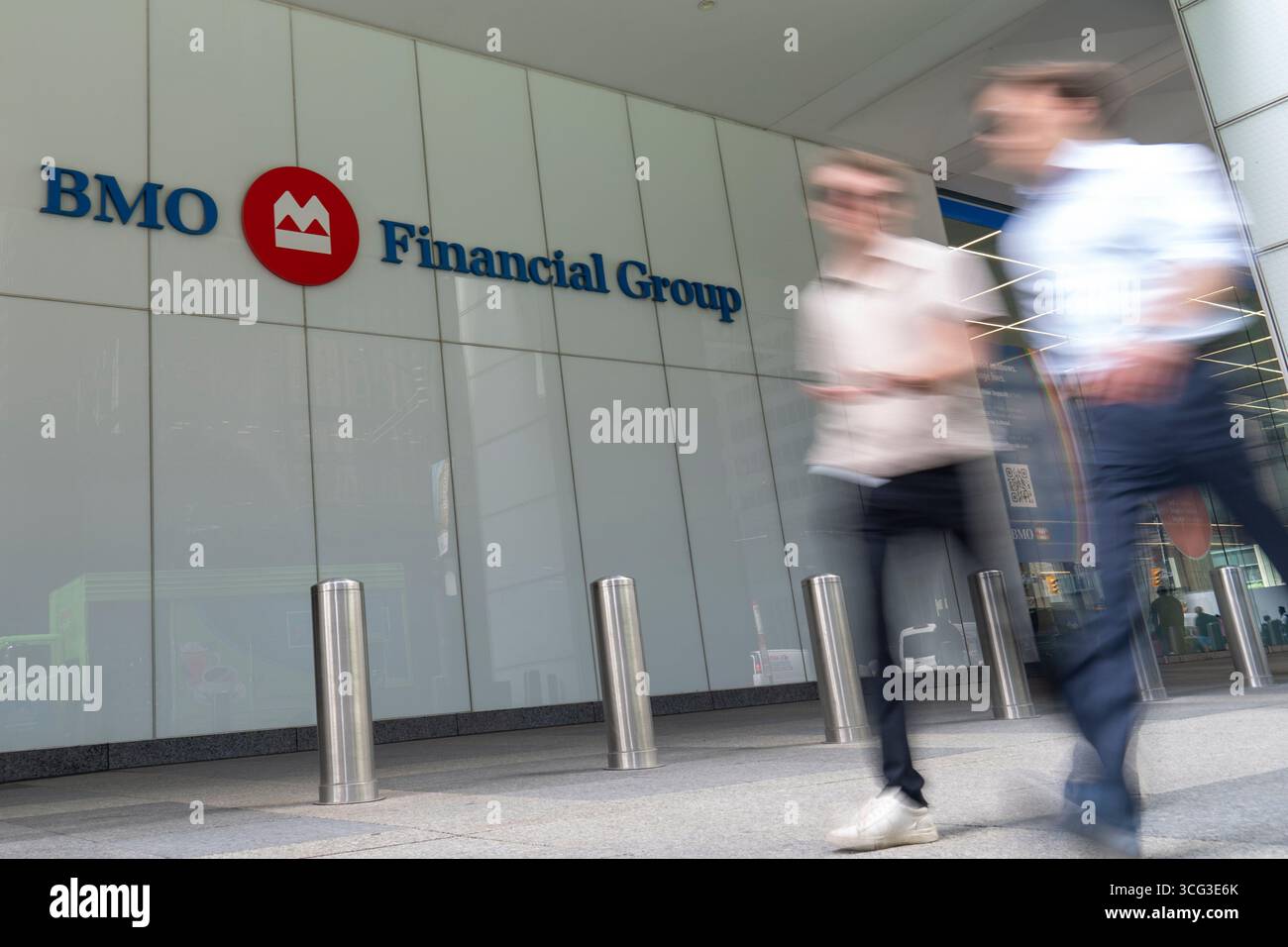 People make their way past the Bank of Montreal (BMO) building in the ...
