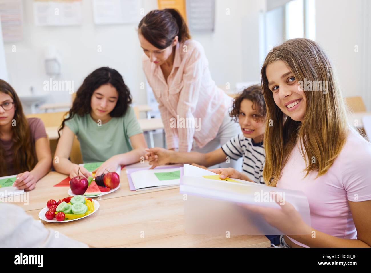 A group of students and a teacher learning together in a classroom ...