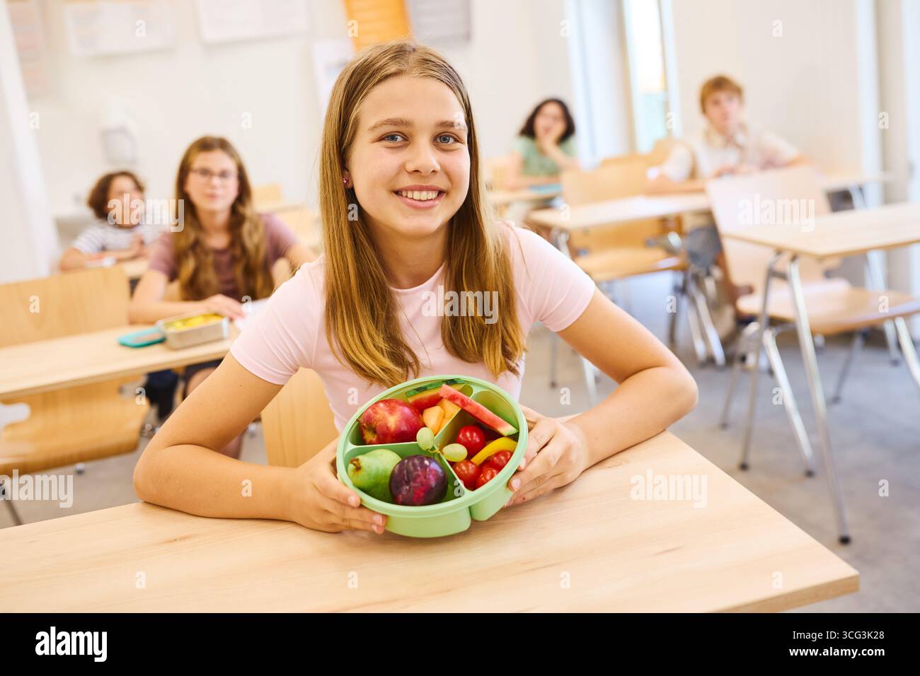 A cheerful student in a bright classroom holding a bowl of vibrant ...