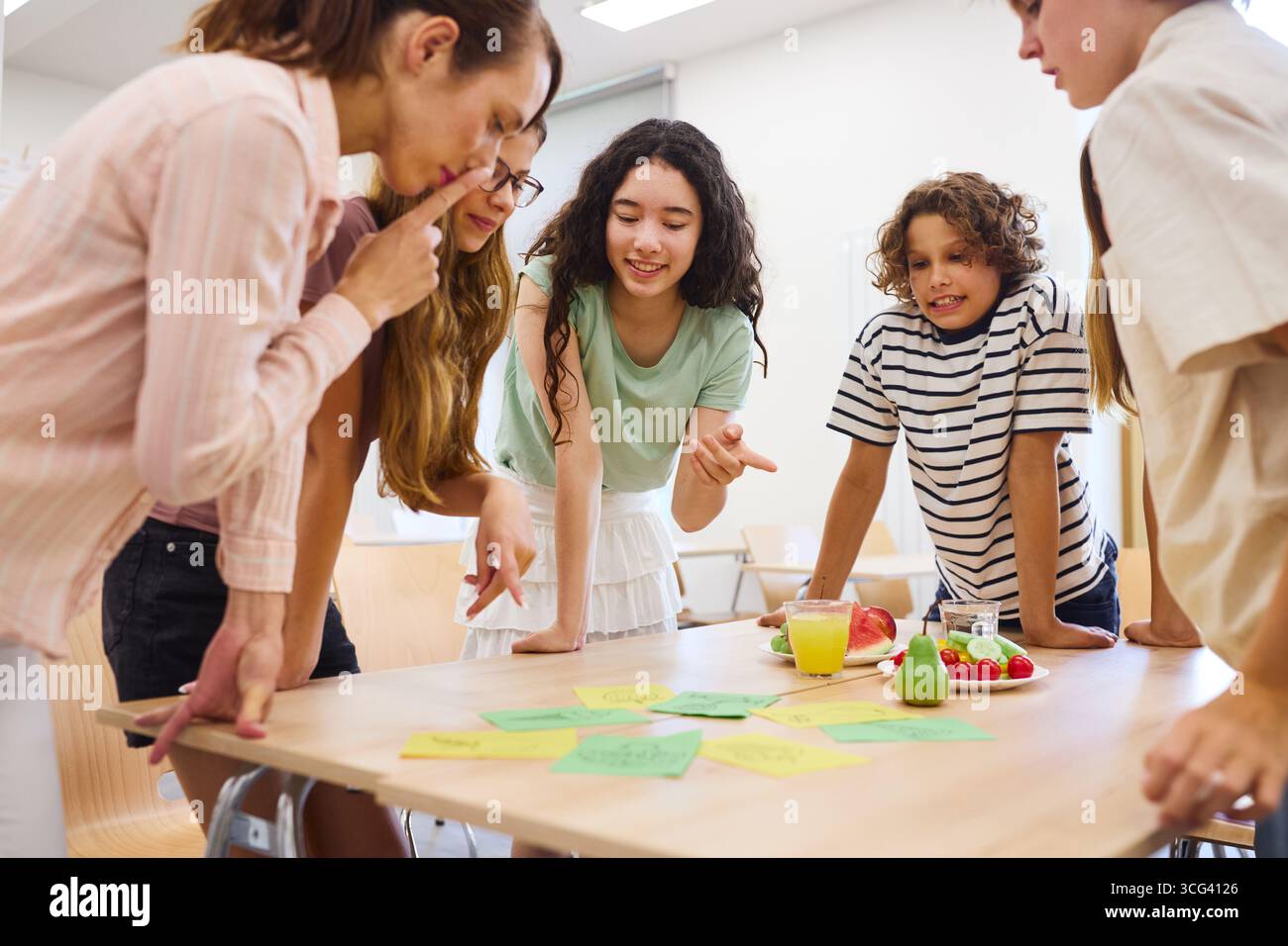 Students of diverse ages discussing and collaborating around a table in ...