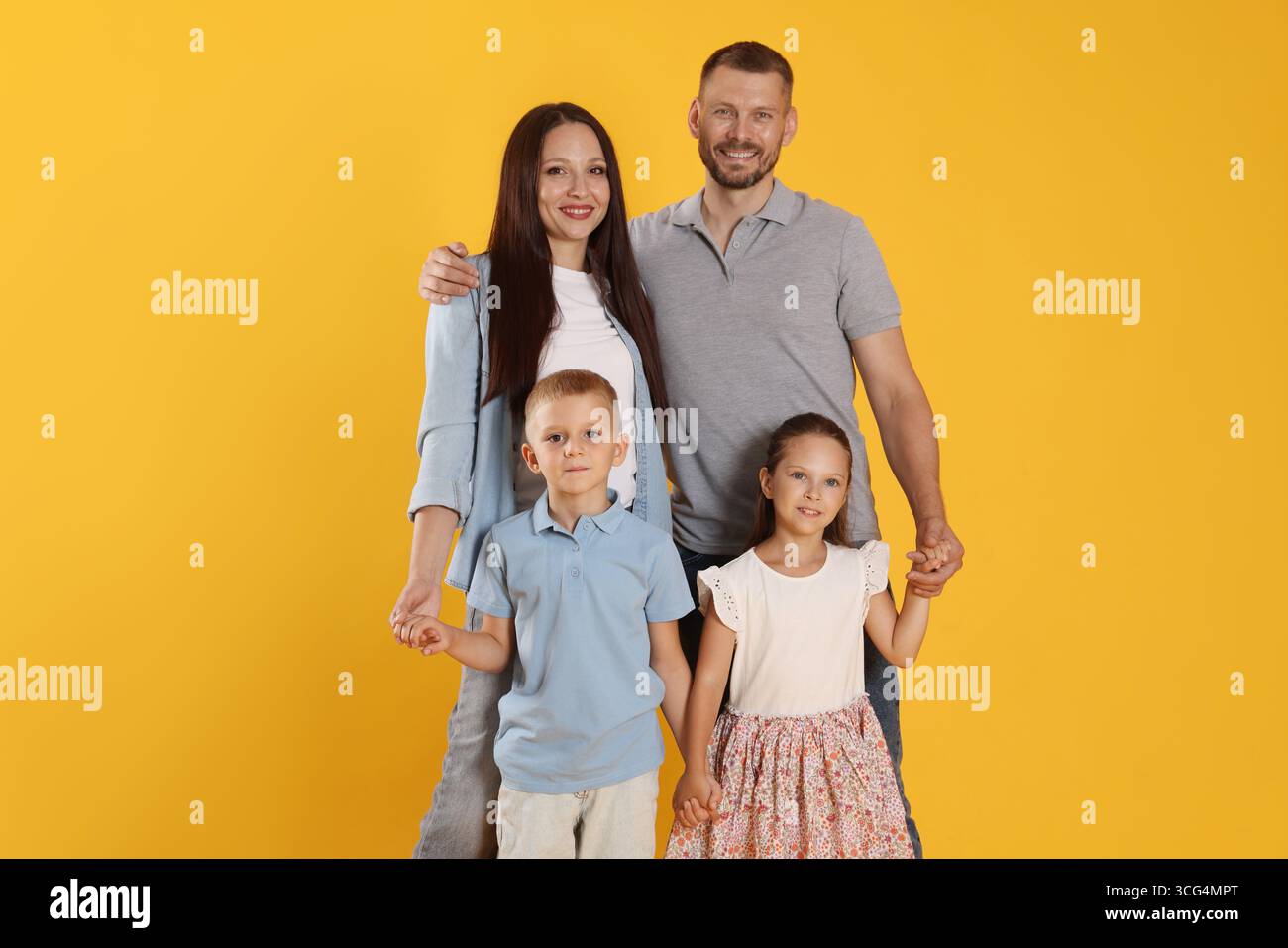 Portrait of happy family on yellow background Stock Photo - Alamy
