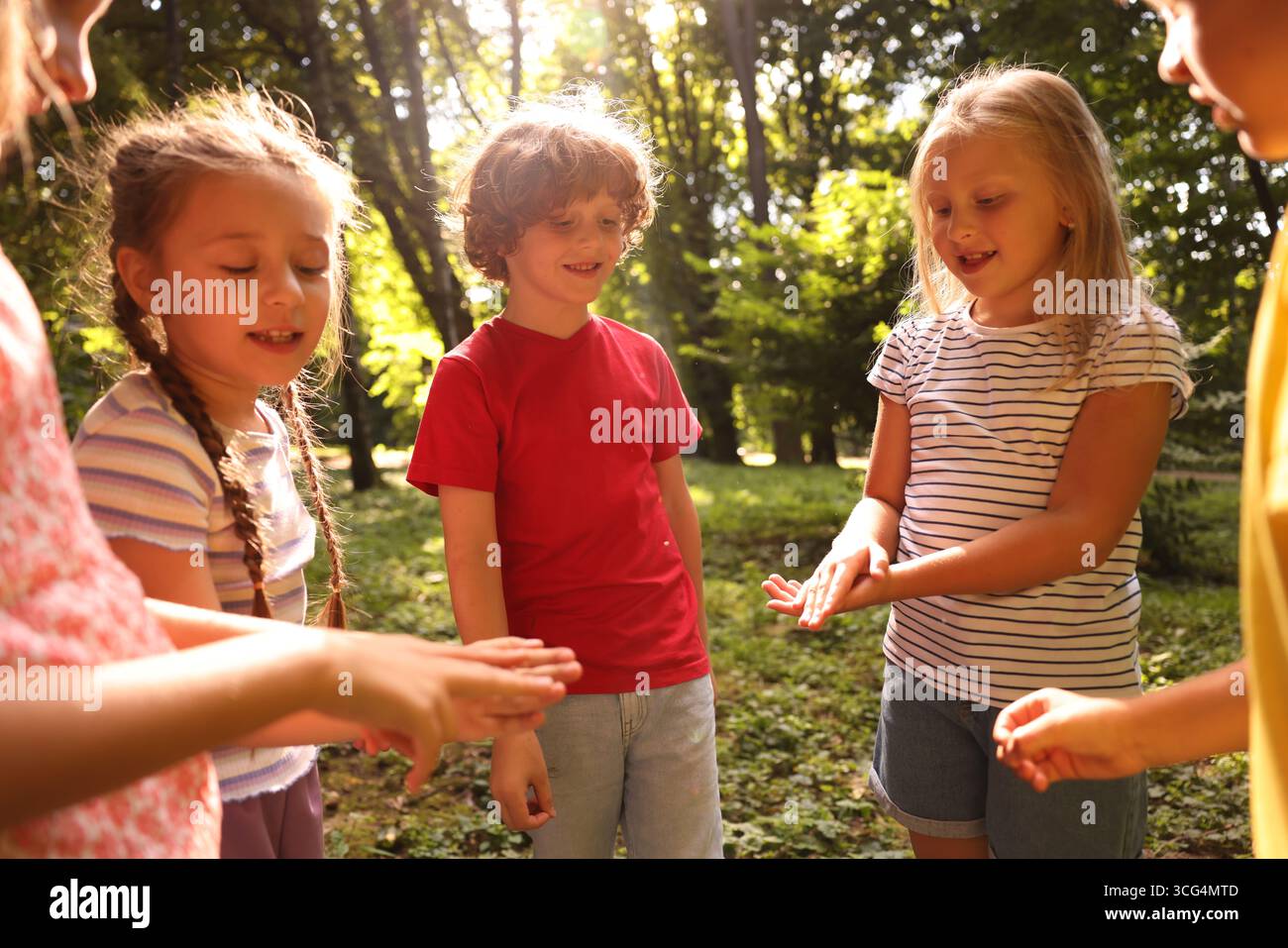 Cute little kids playing rock, paper and scissors in park Stock Photo ...