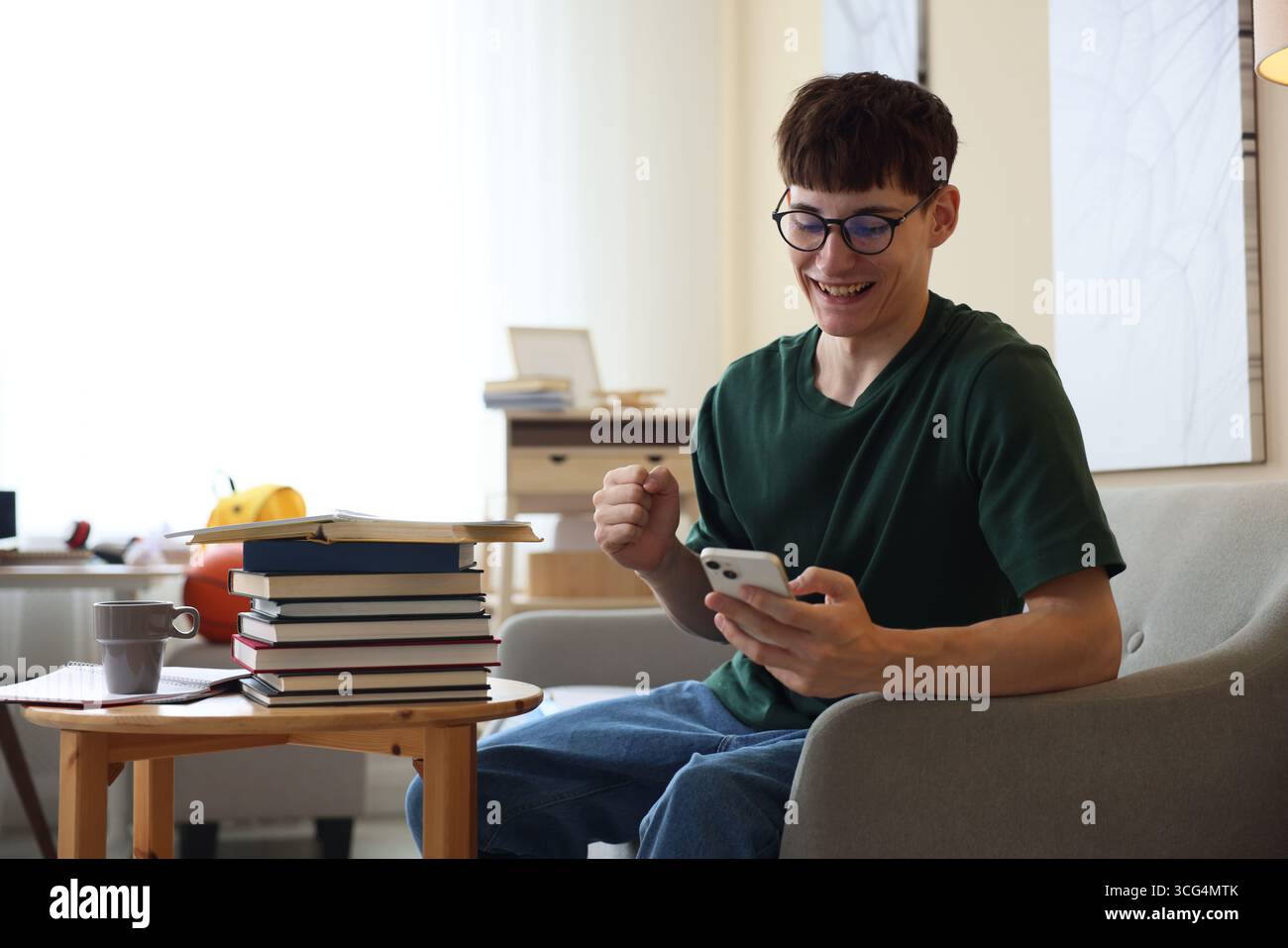 Happy student celebrating good exam result at table indoors Stock Photo ...