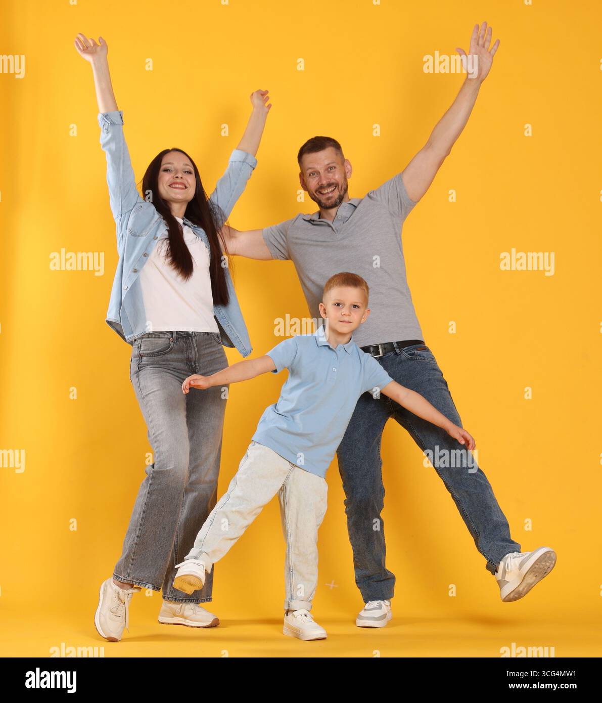 Happy family having fun on yellow background Stock Photo - Alamy
